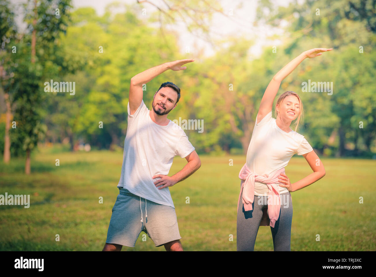 Portrait of Young couple exercise for health in the park at sunset ...