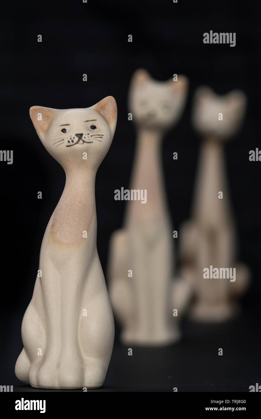 Three different size porcelan cat figurines with long necks and ...
