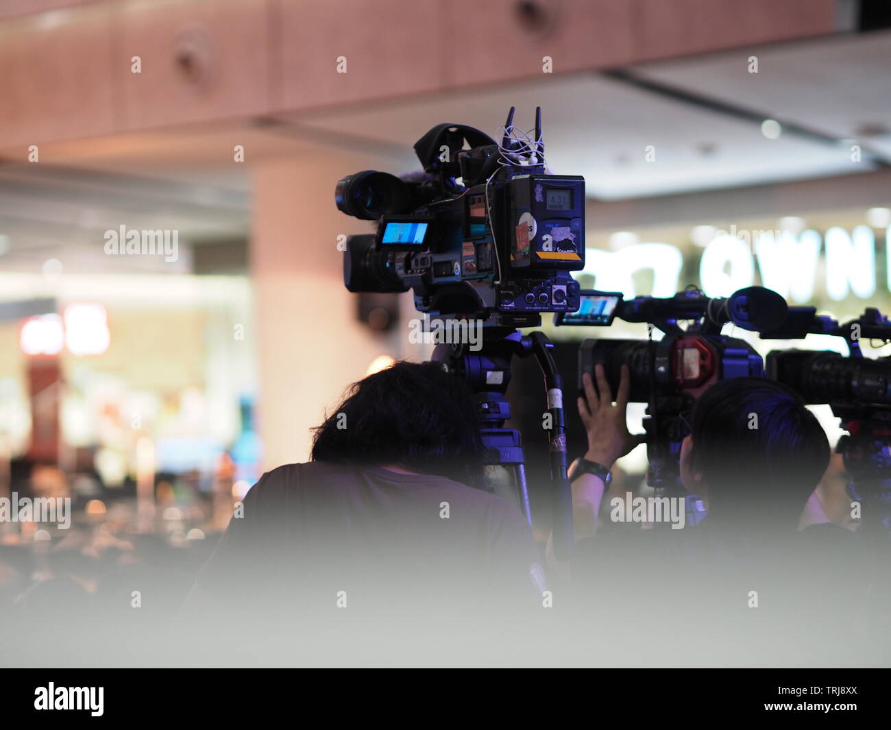 Men standing on camera at the event Stock Photo - Alamy