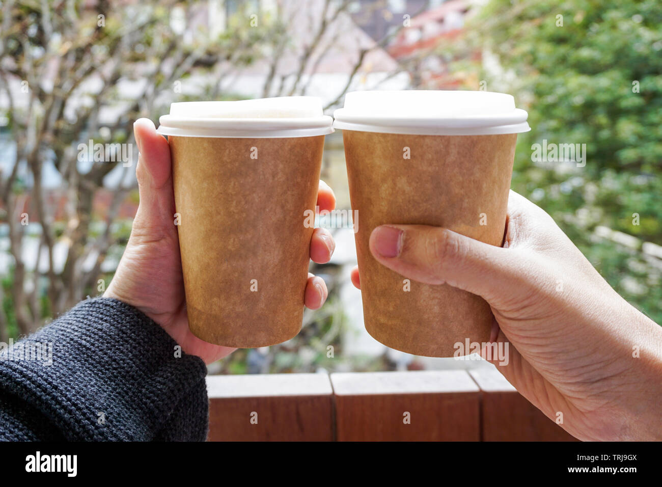 Two hand holding hot coffee cup made from paper Stock Photo - Alamy