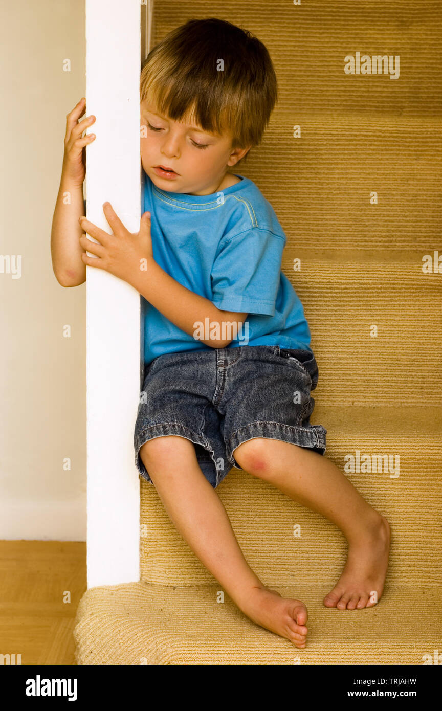 Concept of neglected child. Little boy sitting on the stairs of the ...