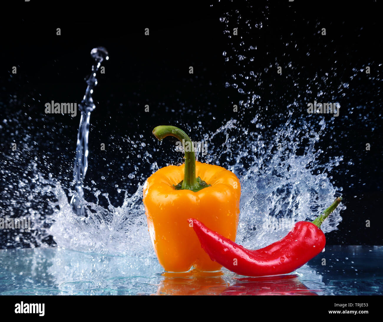 Pepper in spray of water. Juicy pepper with splash on black background ...