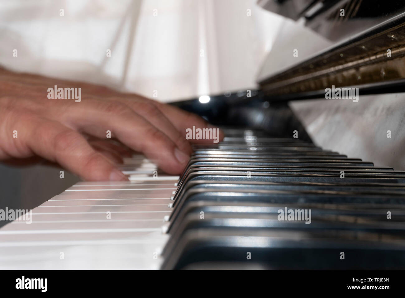 Hands playing piano while moving move effect close up Stock Photo - Alamy