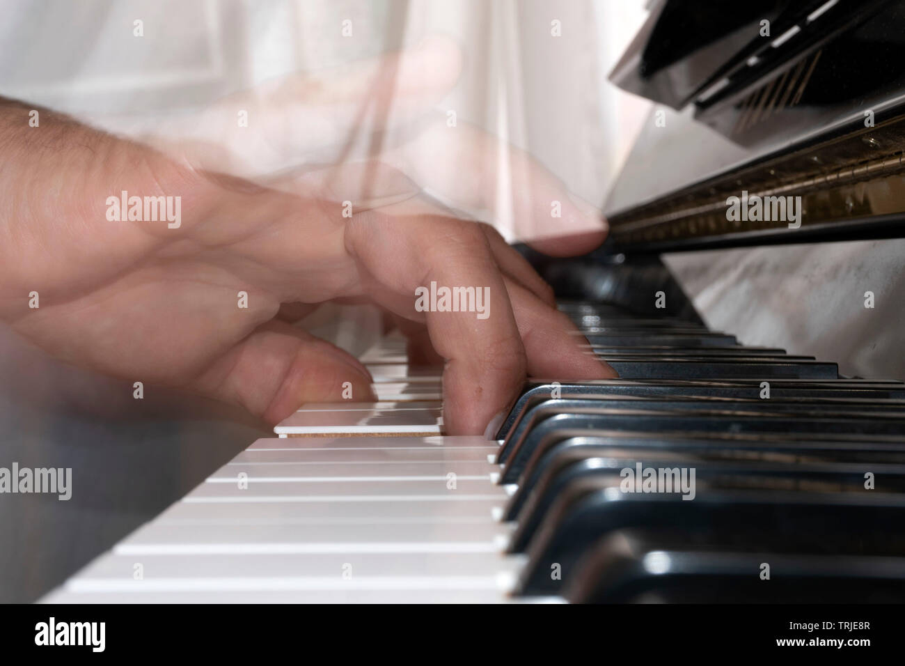 Hands playing piano while moving move effect close up Stock Photo - Alamy
