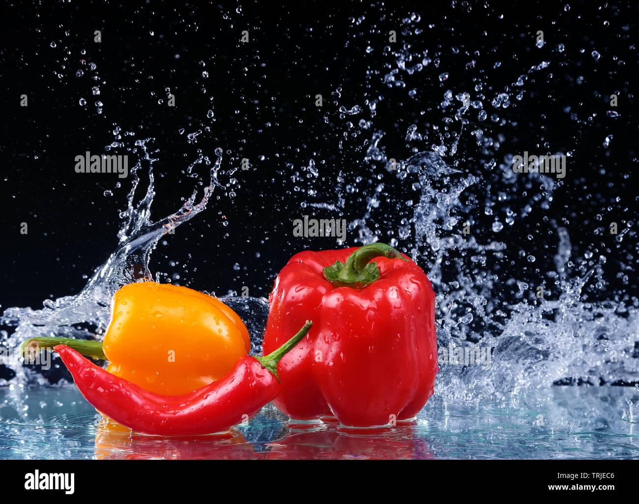 Pepper in spray of water. Juicy pepper with splash on black background ...