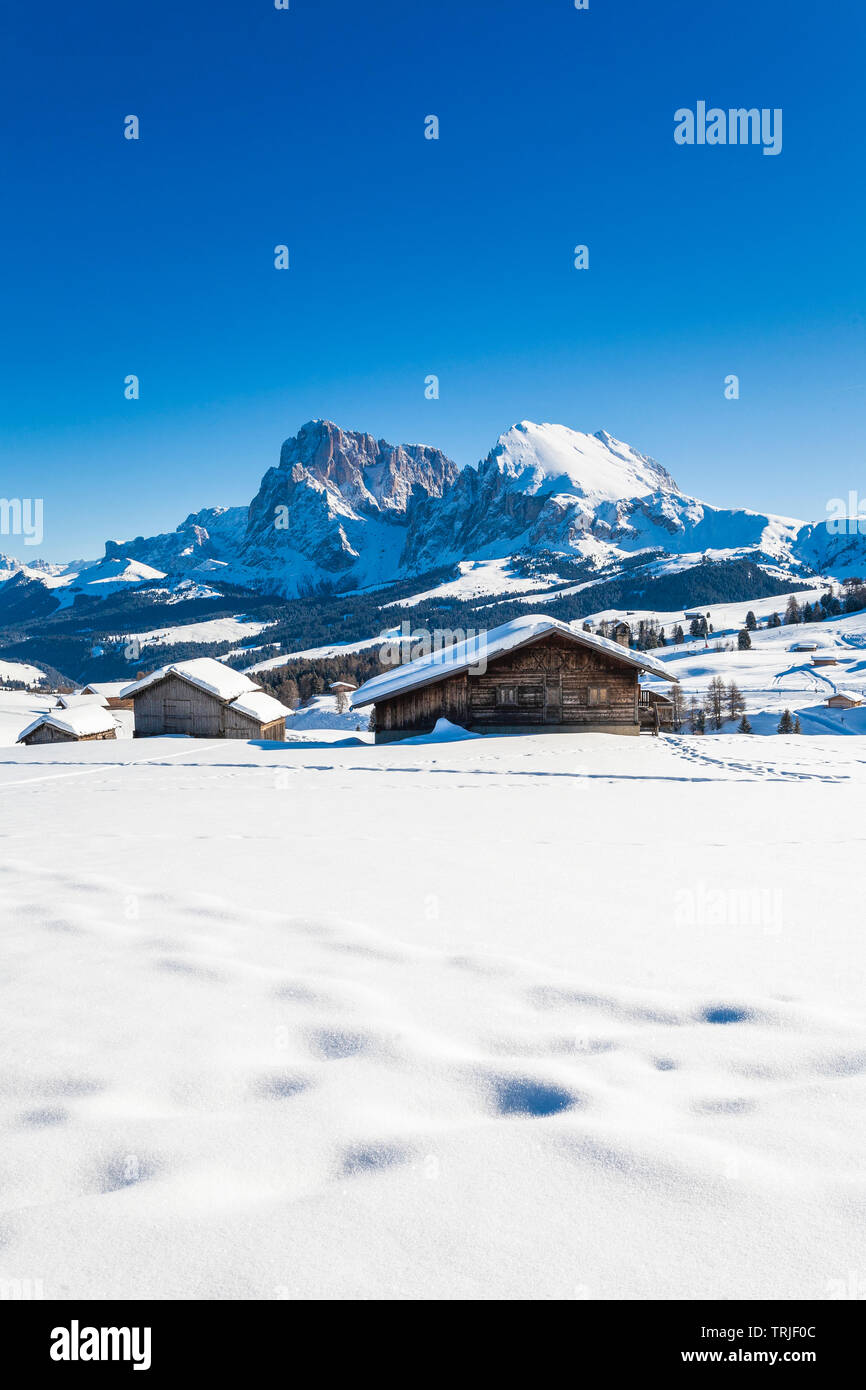 Wood huts in the snow with Sassopiatto and Sassolungo in background ...