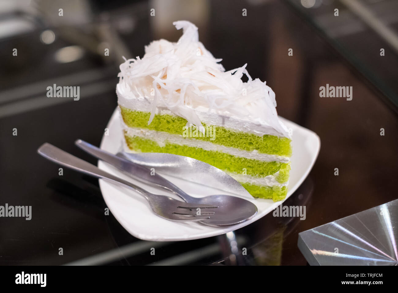 Pandan cake topped fresh coconut in creamy layers on plate Stock Photo ...