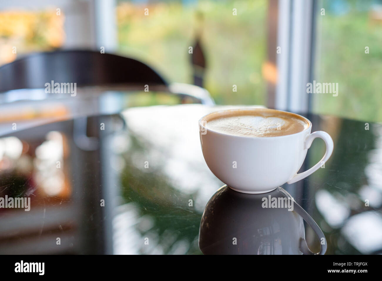 Coffee cup reflection on glass table in cafe Stock Photo - Alamy