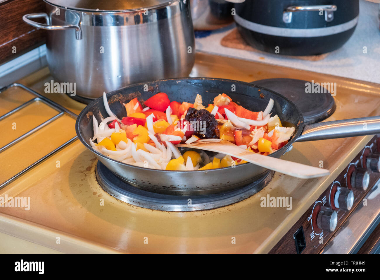 Wooden flipper frying chili sauce, vegetable,herb and oil in pan Stock ...