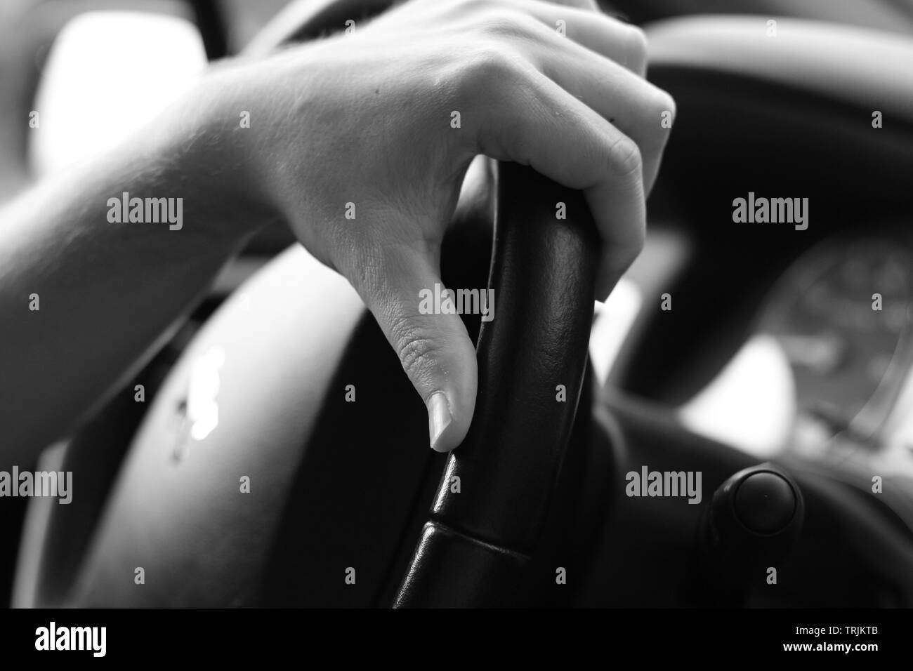 The left hand of the driver on the steering wheel of a car Stock Photo ...