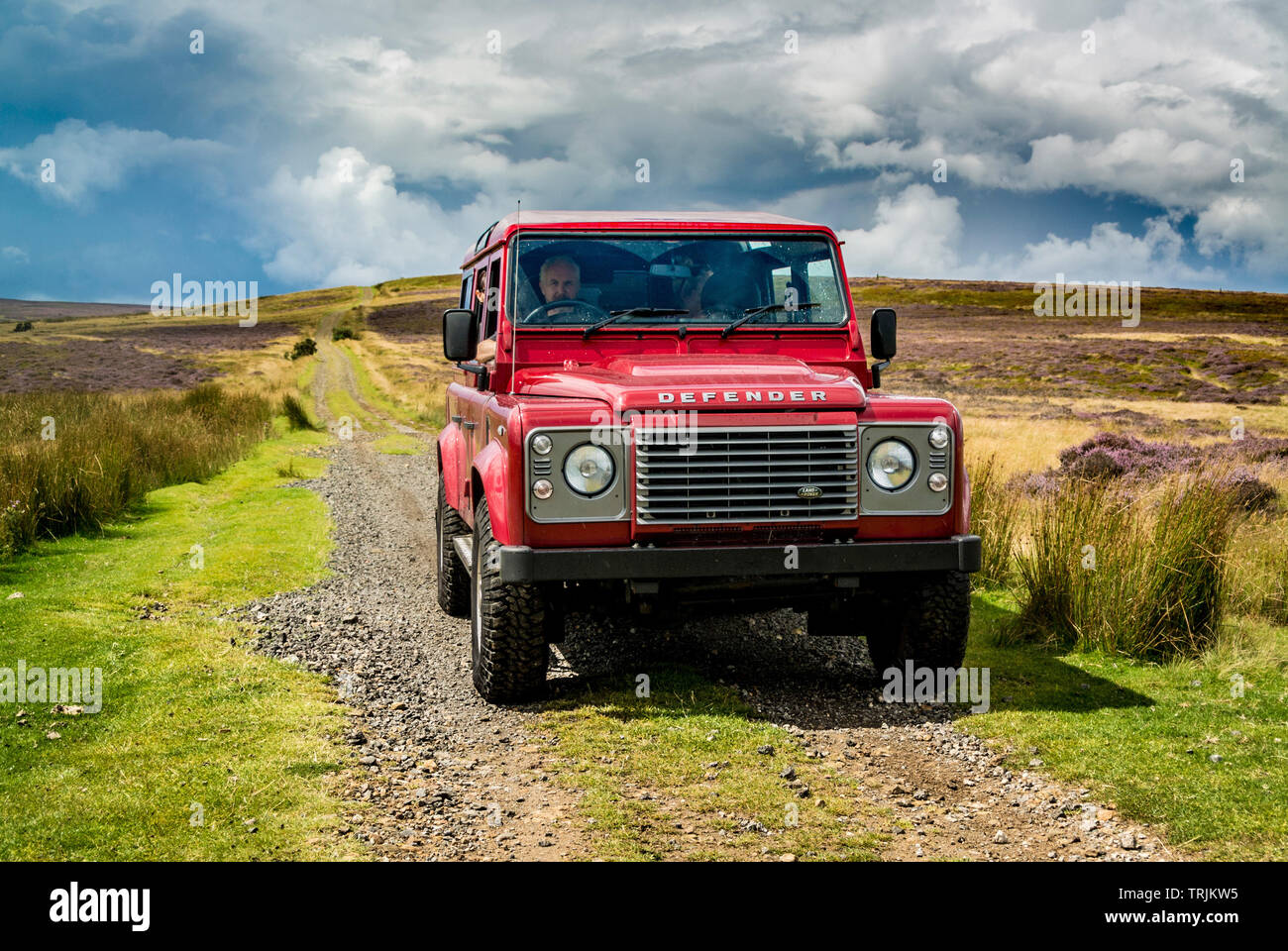 Red Land Rover Defender 110 4WD car navigating a Green Lane track ...