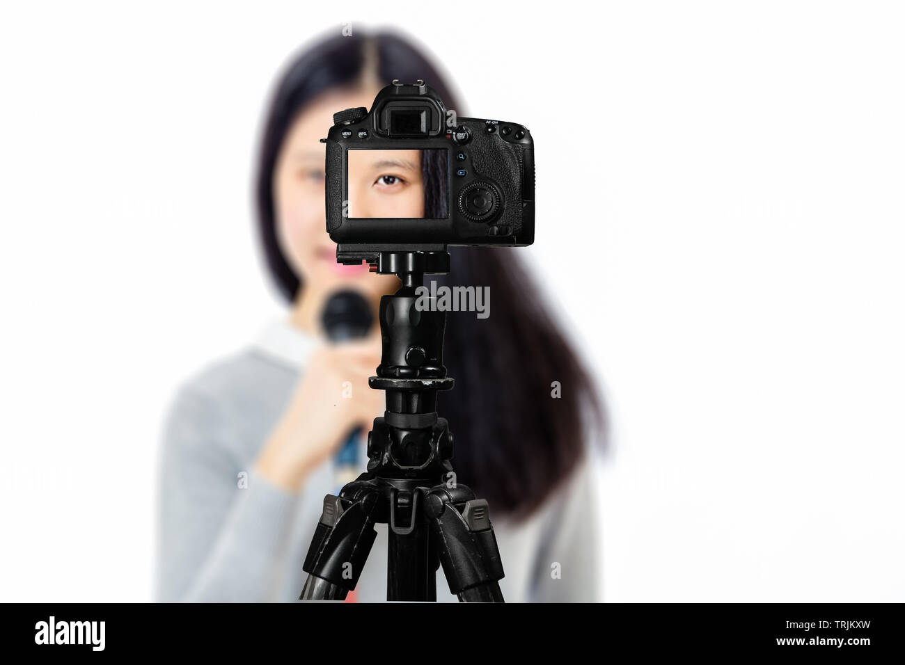 Focus on live view on camera on tripod, teenage girl singing with ...