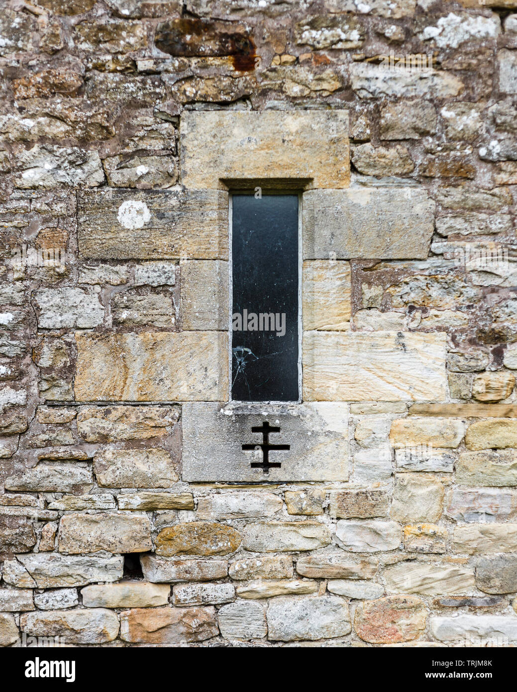 A narrow window wth an unusual design below it, in Featherstone Castle ...