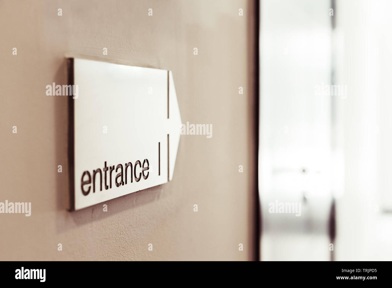 Entrance sign with direction arrow on the wall in modern building Stock ...