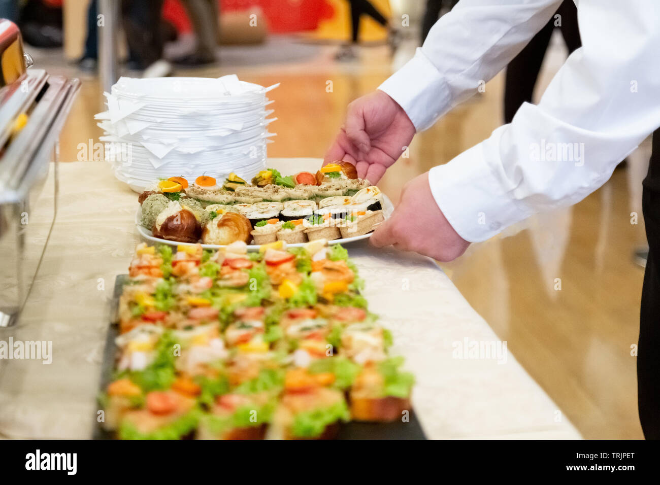 Close up of waiter hands serving canapes on buffet table Stock Photo ...