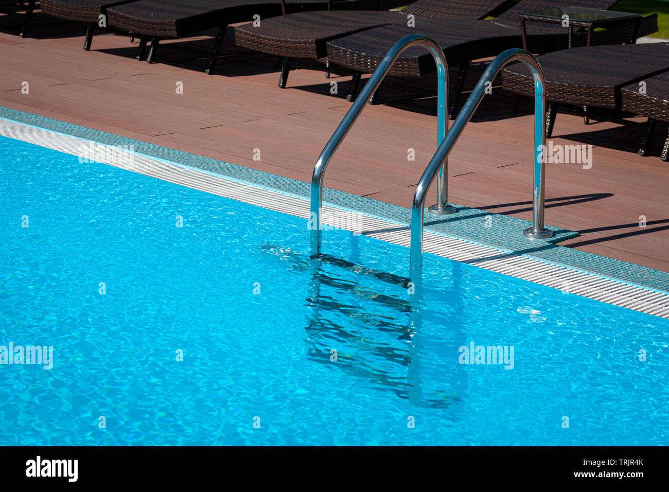 Handrail on pool. Swimming pool with stair at tropical resort. Water ...