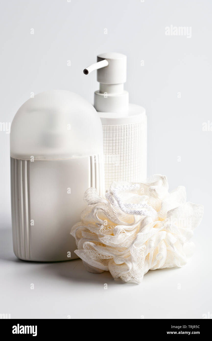 Bath cosmetic products and white sponge on light background. Closeup ...