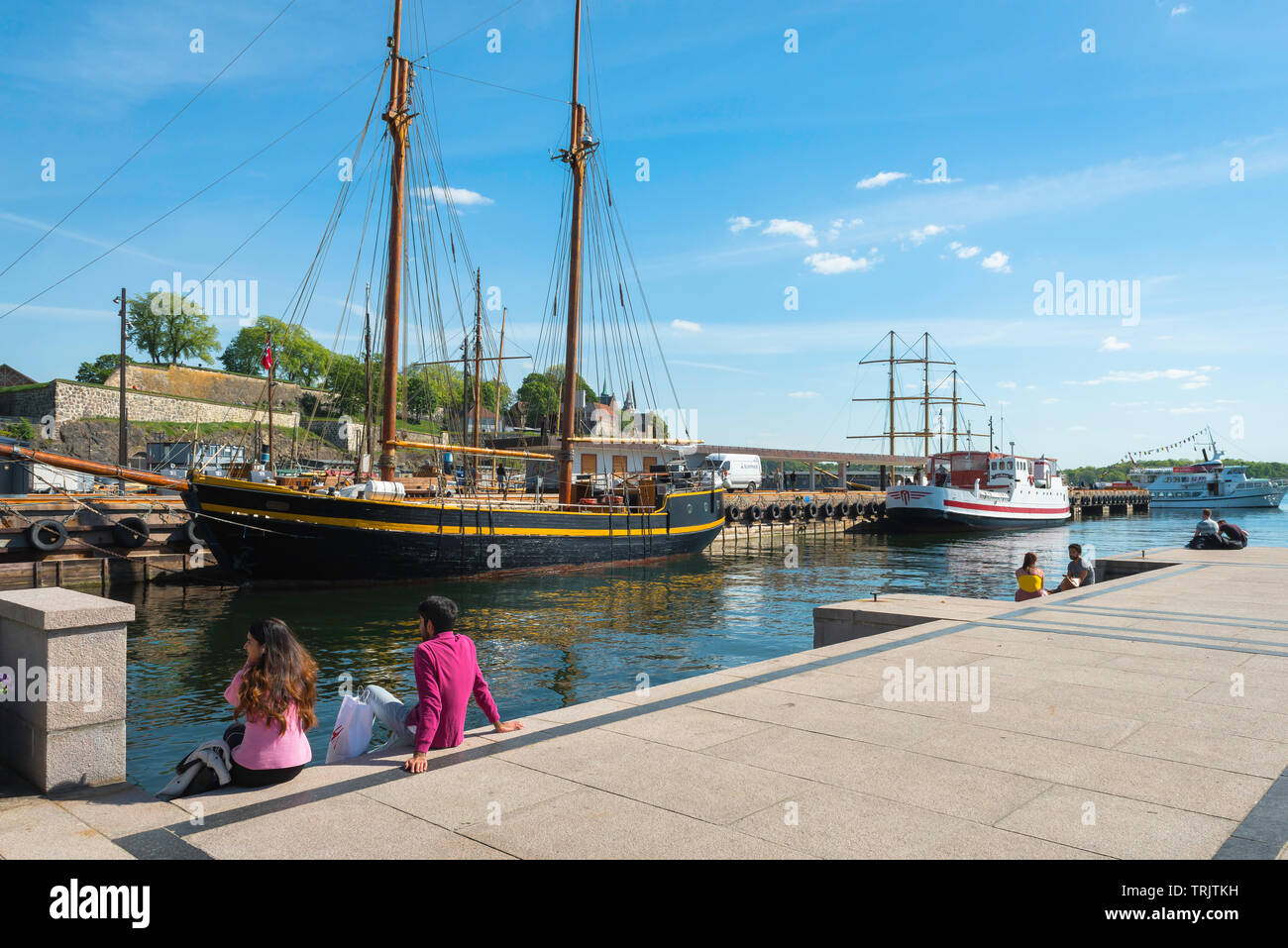 Harbor Oslo waterfront, rear view in summer of young people relaxing ...