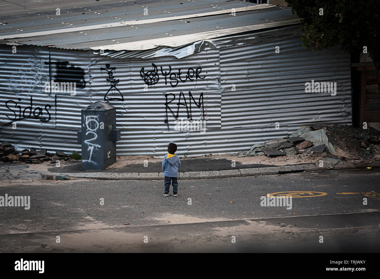 Young child looking at the graffiti on the walls in a township in ...