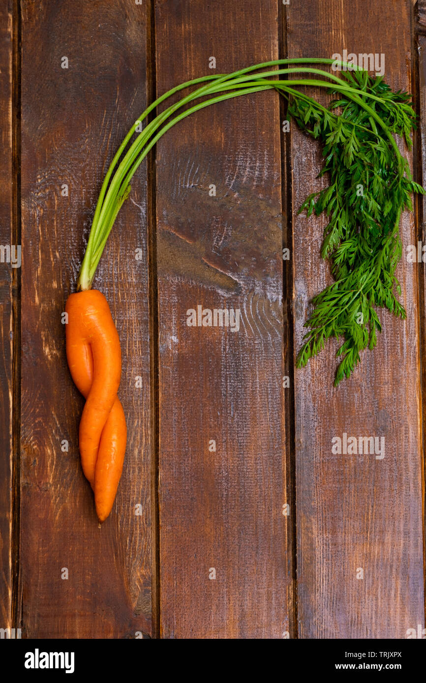 Funny ugly carrot on wooden background. Image with copy space, top view ...