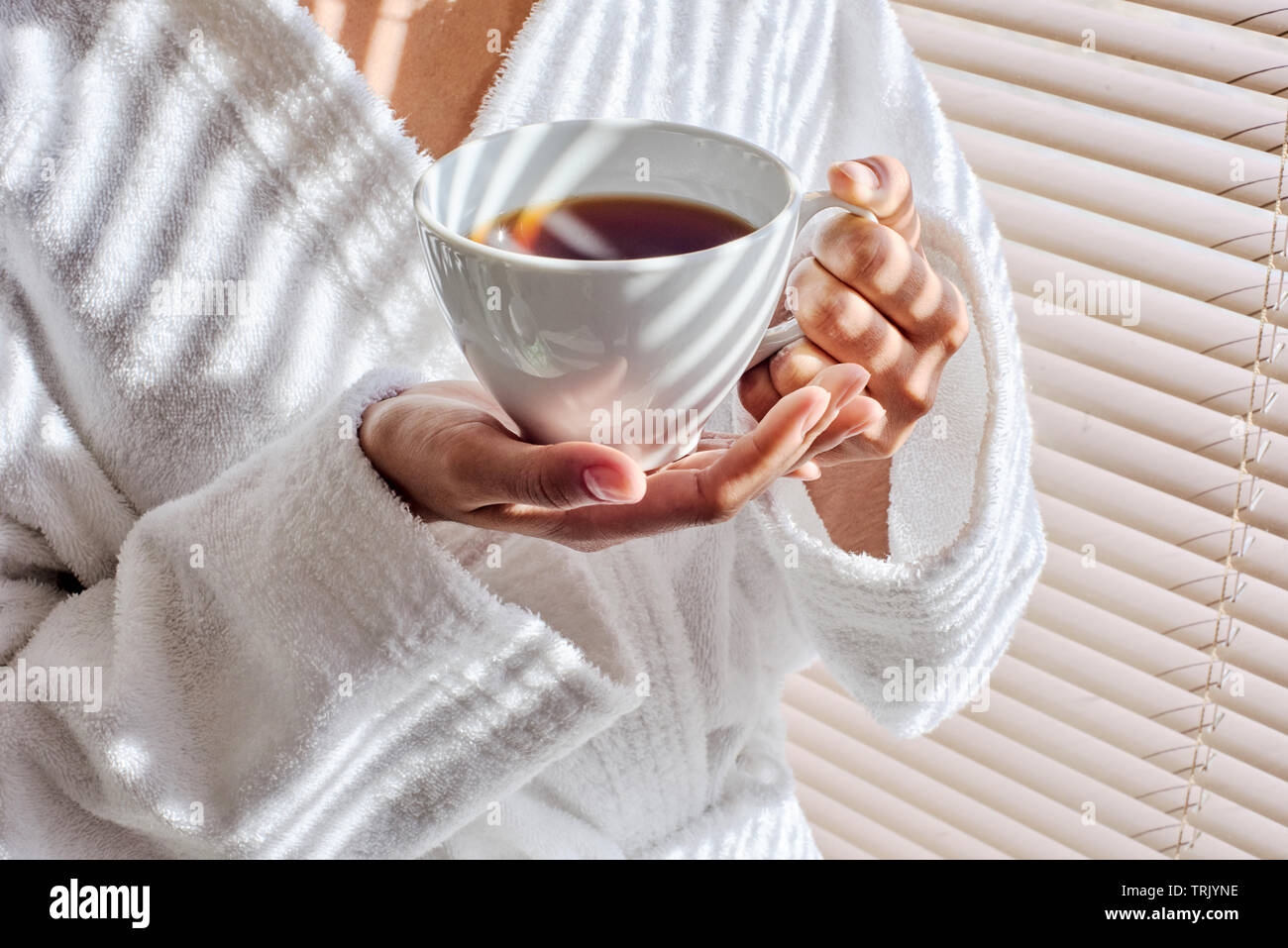 Close up of female hands holding white cup of tea at spa salon ...