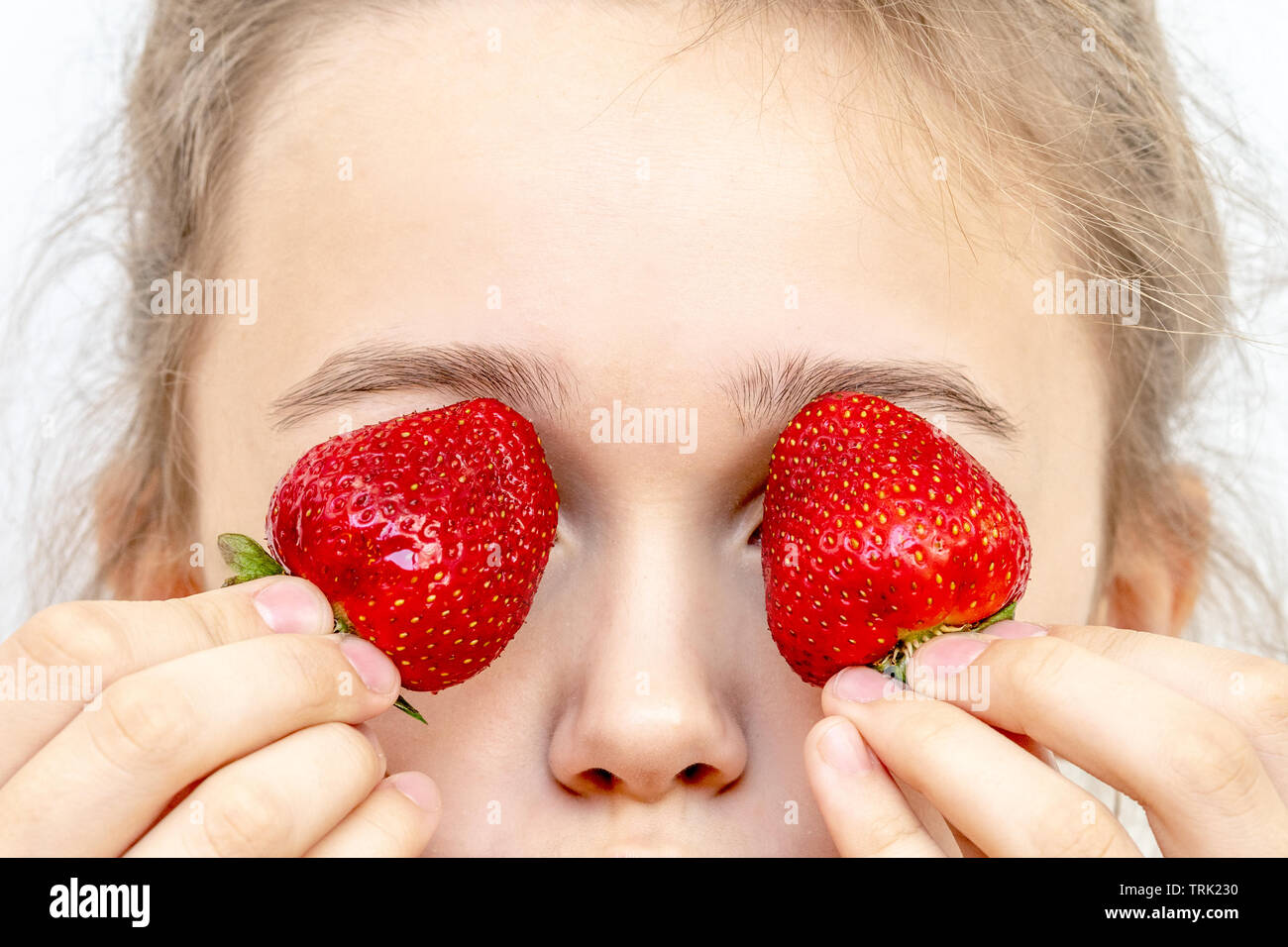 Strawberry Eyes . Beautiful young woman holding strawberries in eyes ...