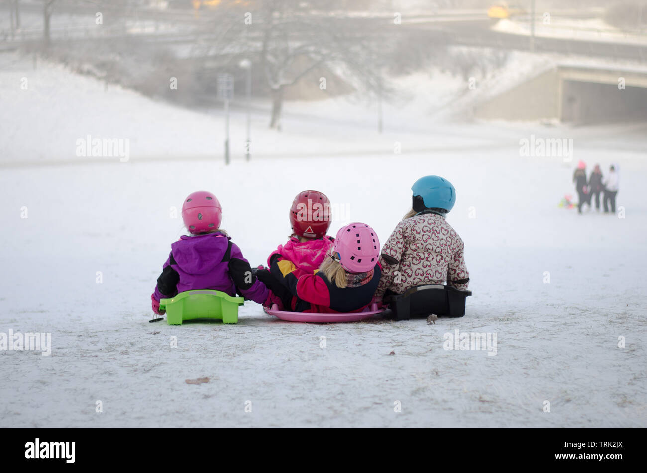 Kids sledding down hill on snowy day hi-res stock photography and ...