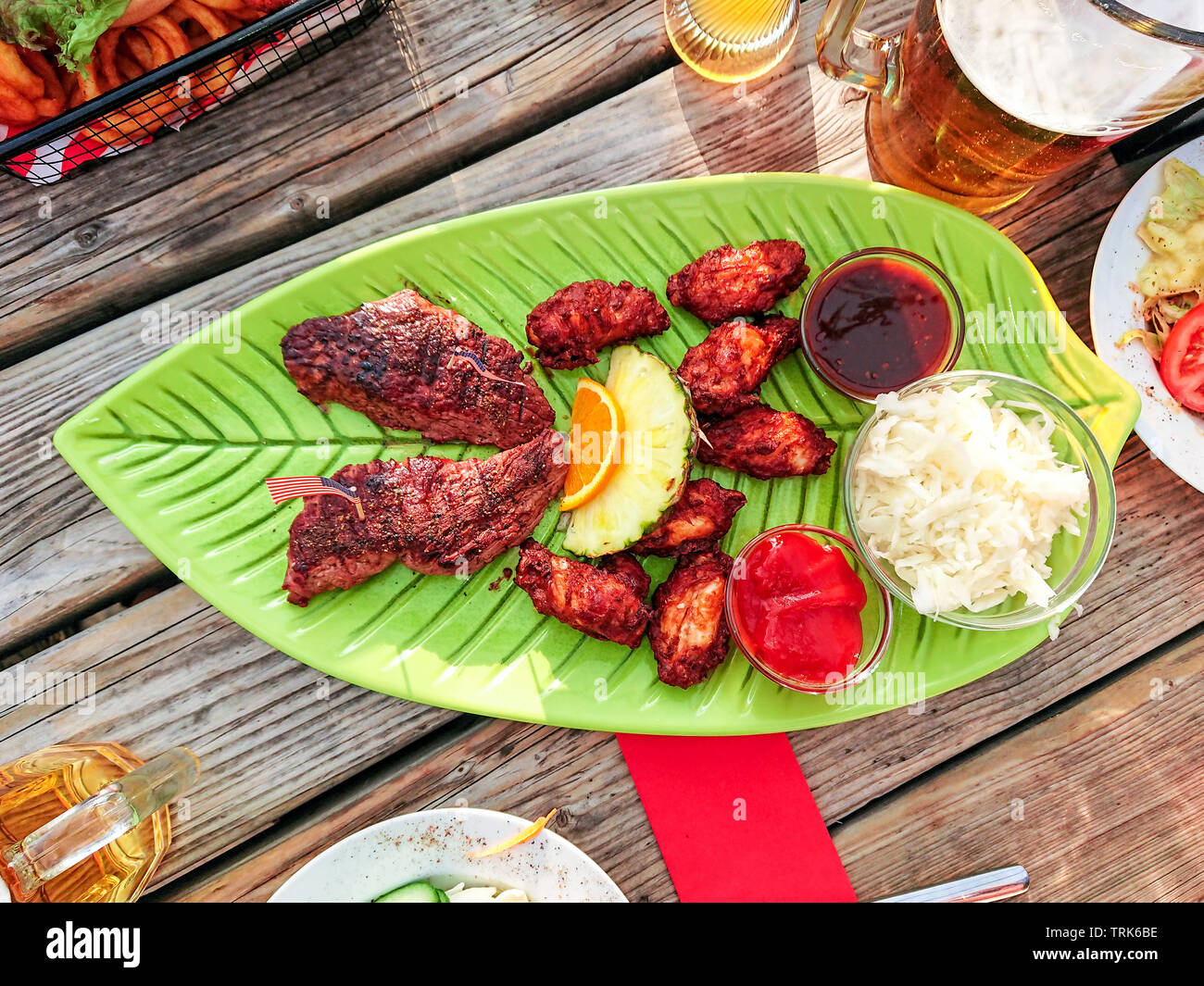 Beef steak with chicken wings and white cabbage salad, top view Stock ...