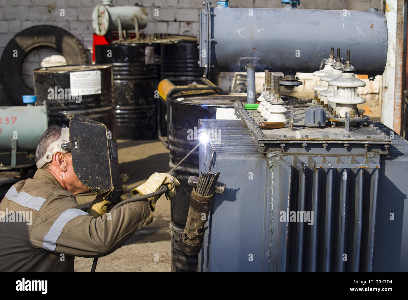 welder repairing an electrical transformer. electrical equipment ...