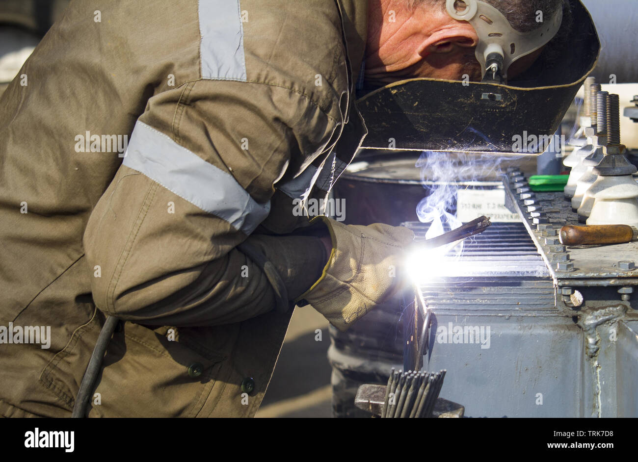 welder repairing an electrical transformer. electrical equipment ...