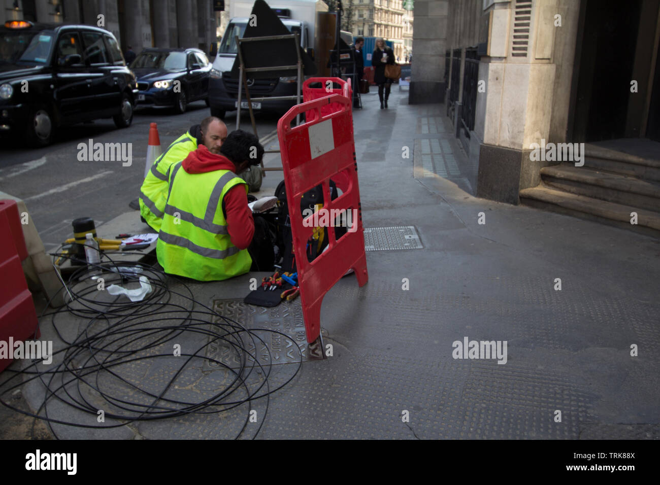 Telecoms engineers working on fibre optic cable cabling in city of ...