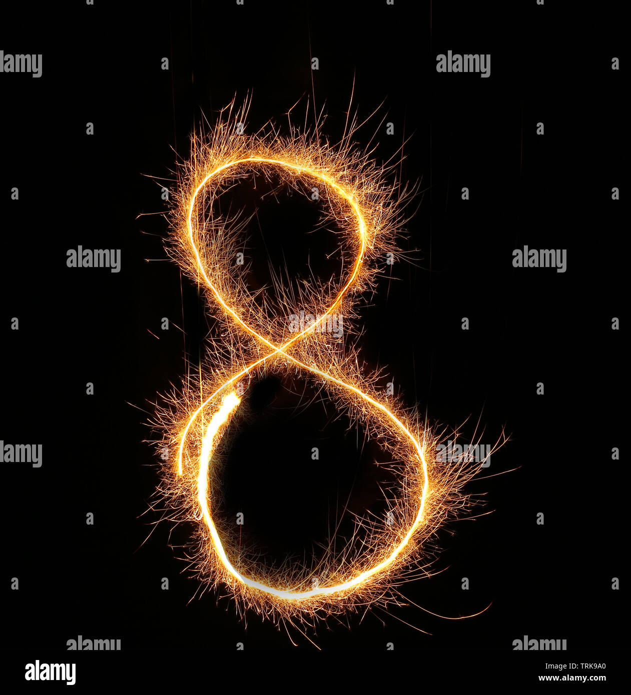 burning sparkler stick and writing sparkling text . number eight ...