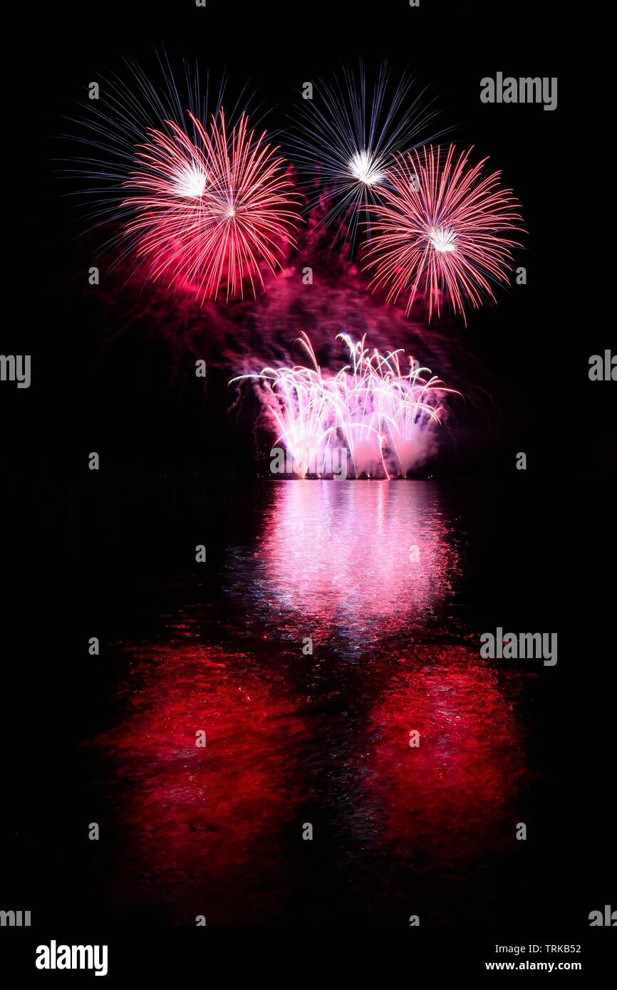Beautiful colorful fireworks on the water surface. Night scene. Concept ...