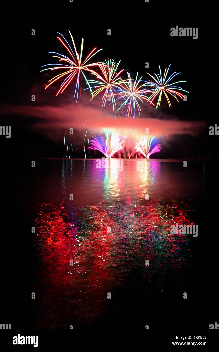 Beautiful colorful fireworks on the water surface. Night scene. Concept ...