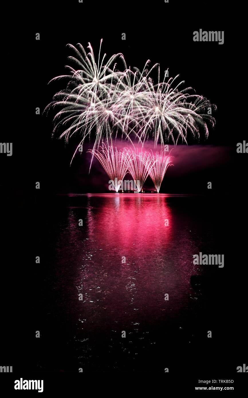 Beautiful colorful fireworks on the water surface. Night scene. Concept ...
