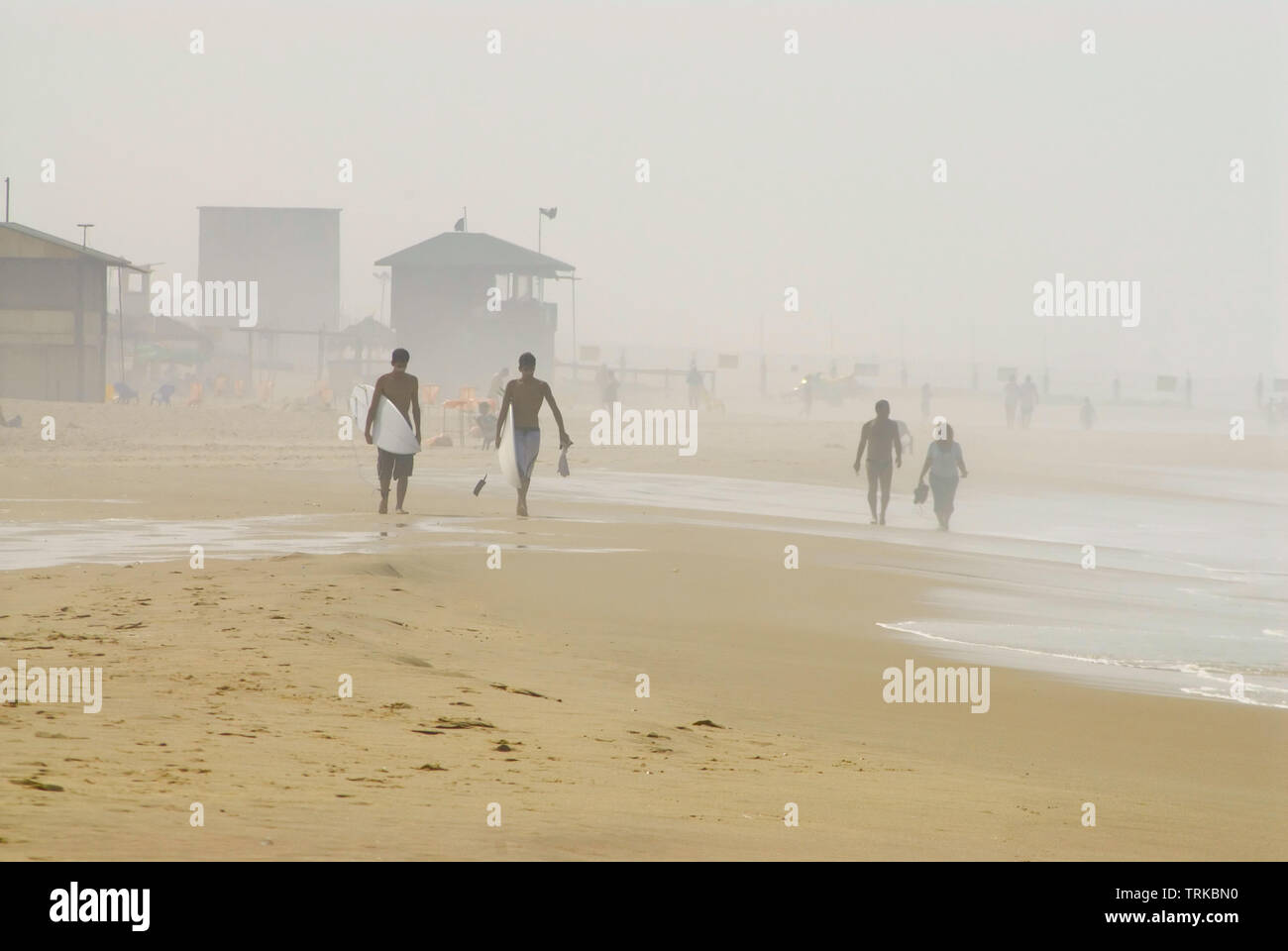Sand beach, walking people in mist Stock Photo - Alamy