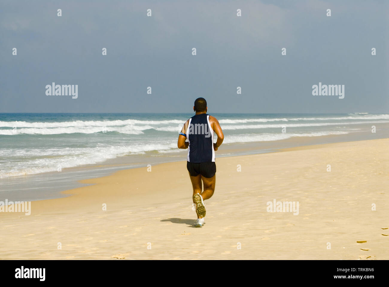 Man running along the beach hi-res stock photography and images - Alamy