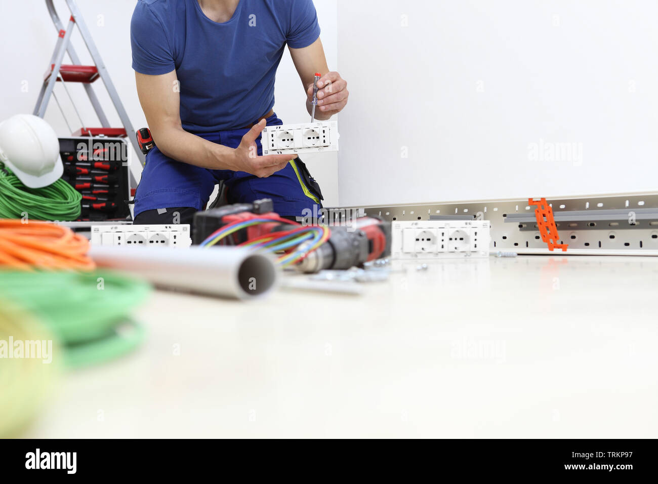 electrician at work with screwdriver in hand connects the cables to the ...