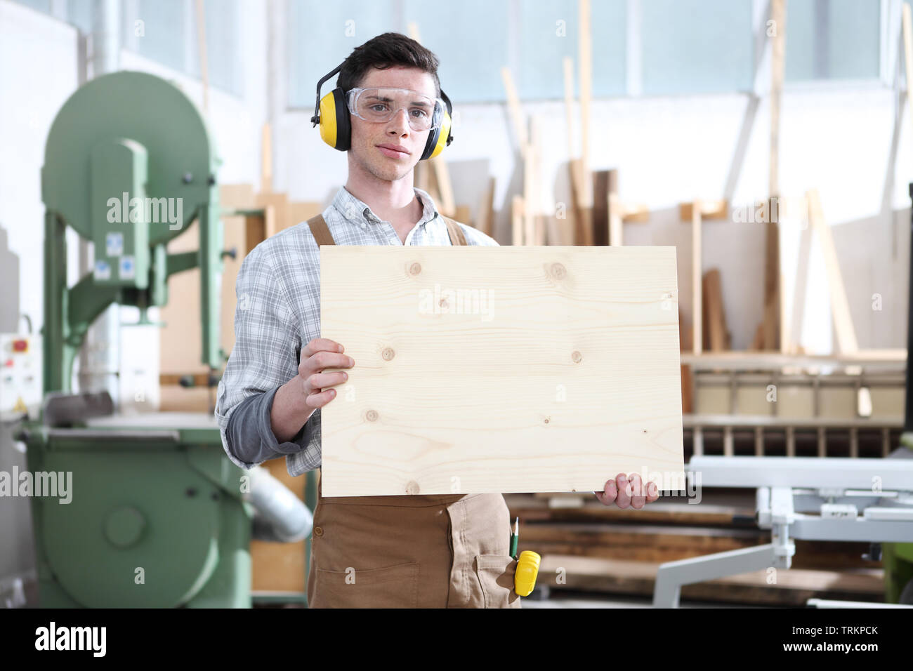 carpenter man show the wooden placard isolated on carpentry background ...