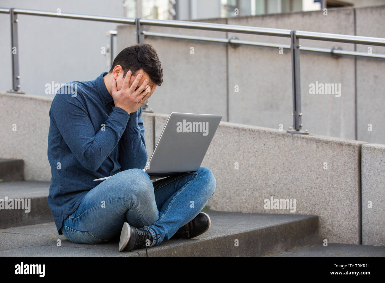 Stressed student covering his face preparing for an exam in campus area ...