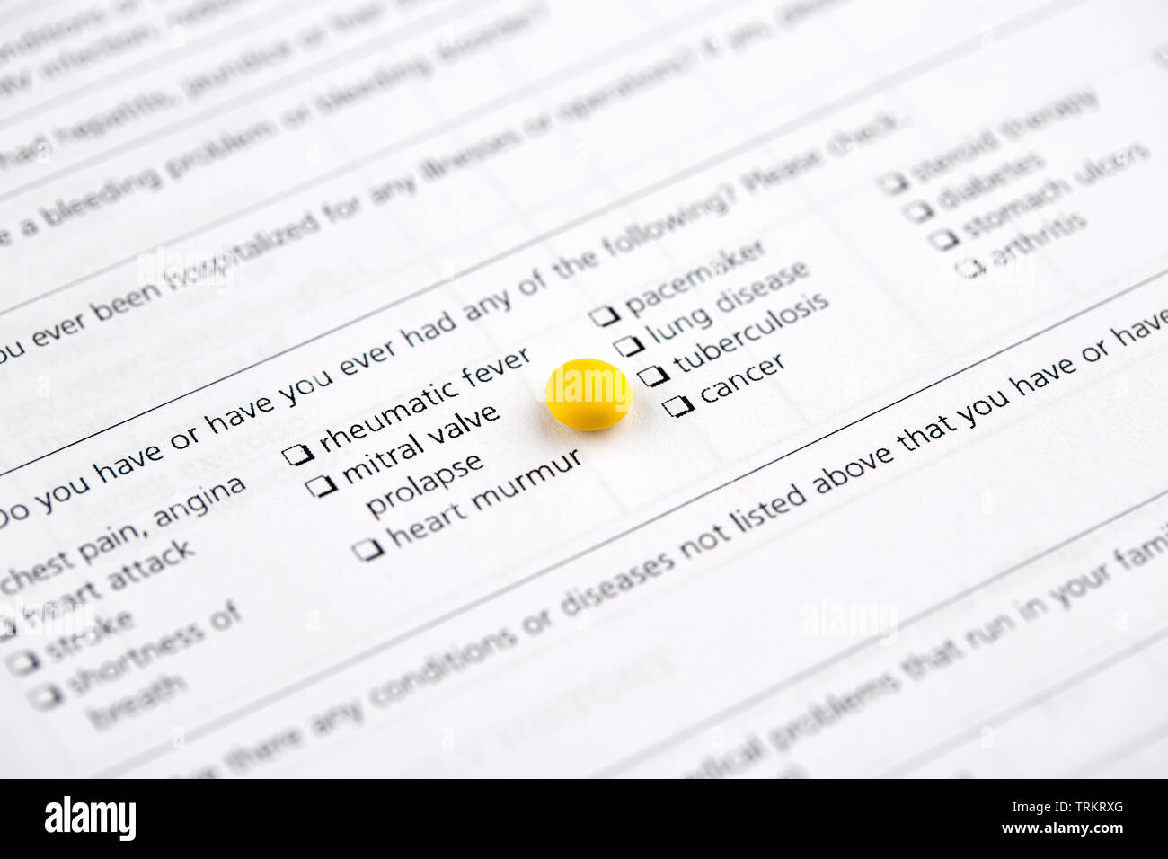 Small round yellow pill on medical questionnaire form Stock Photo - Alamy