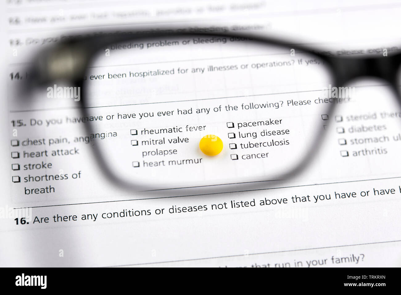 Glasses and yellow pill on medical questionnaire form Stock Photo - Alamy