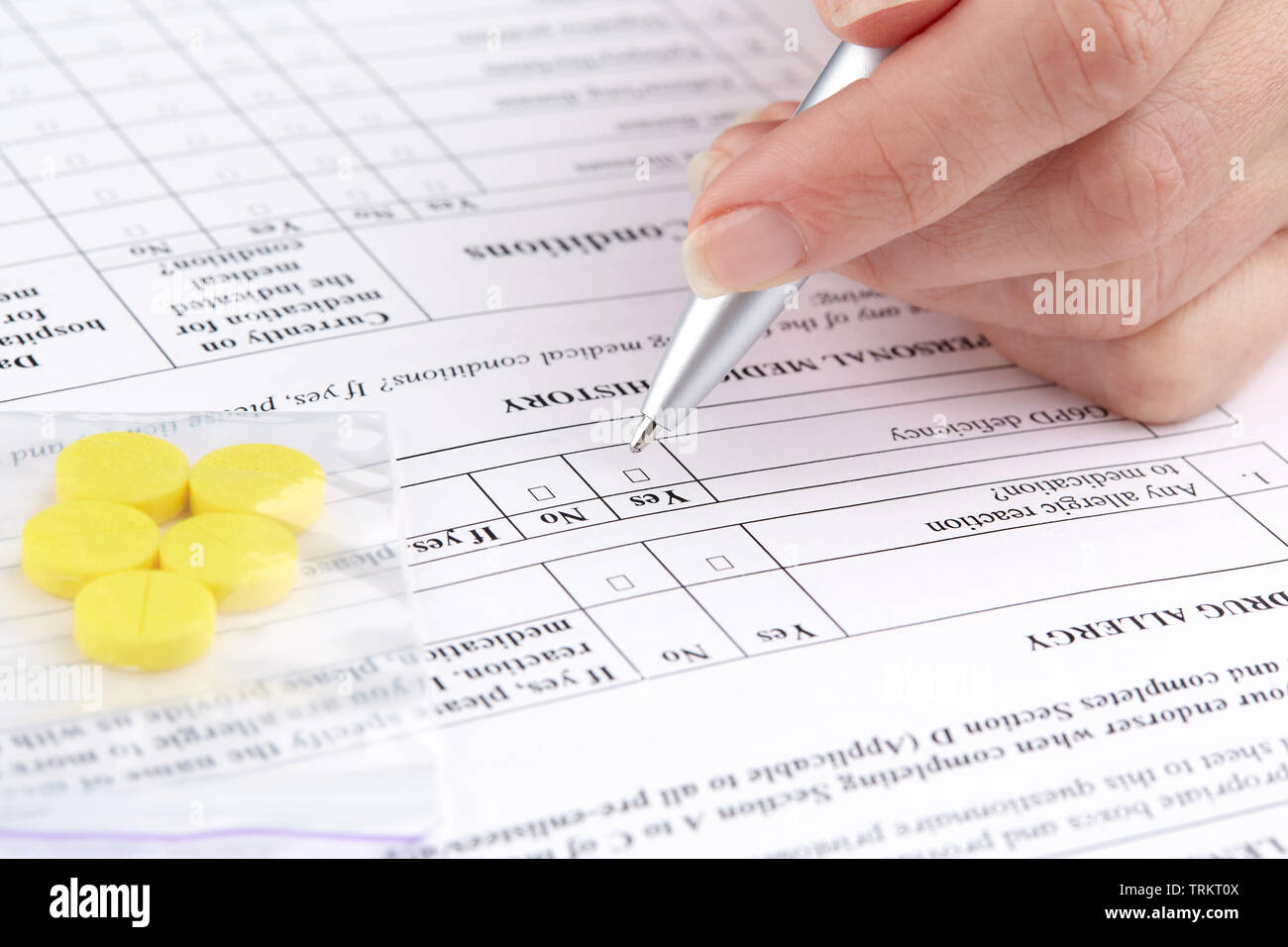 Yellow pills and hand writing on medical questionnaire form Stock Photo ...