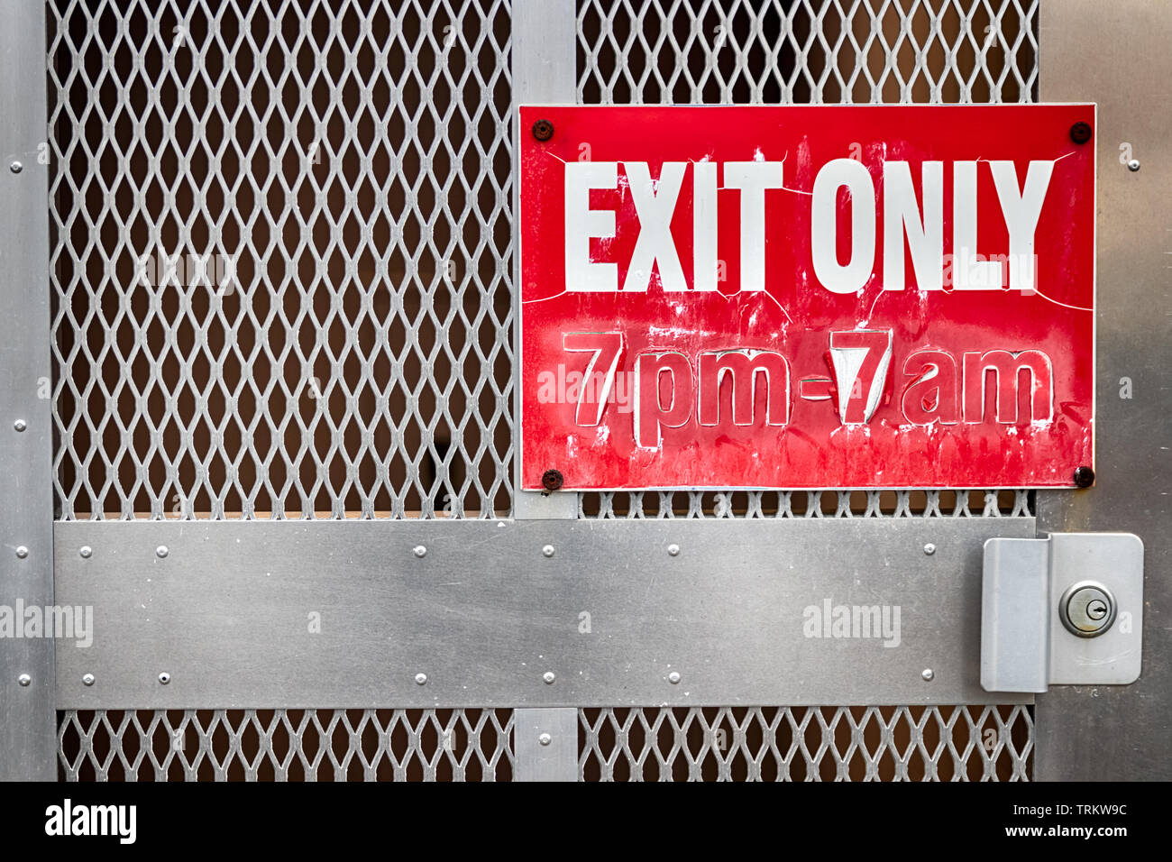 Faded worn exit only sign on a steel gate in daylight Stock Photo - Alamy