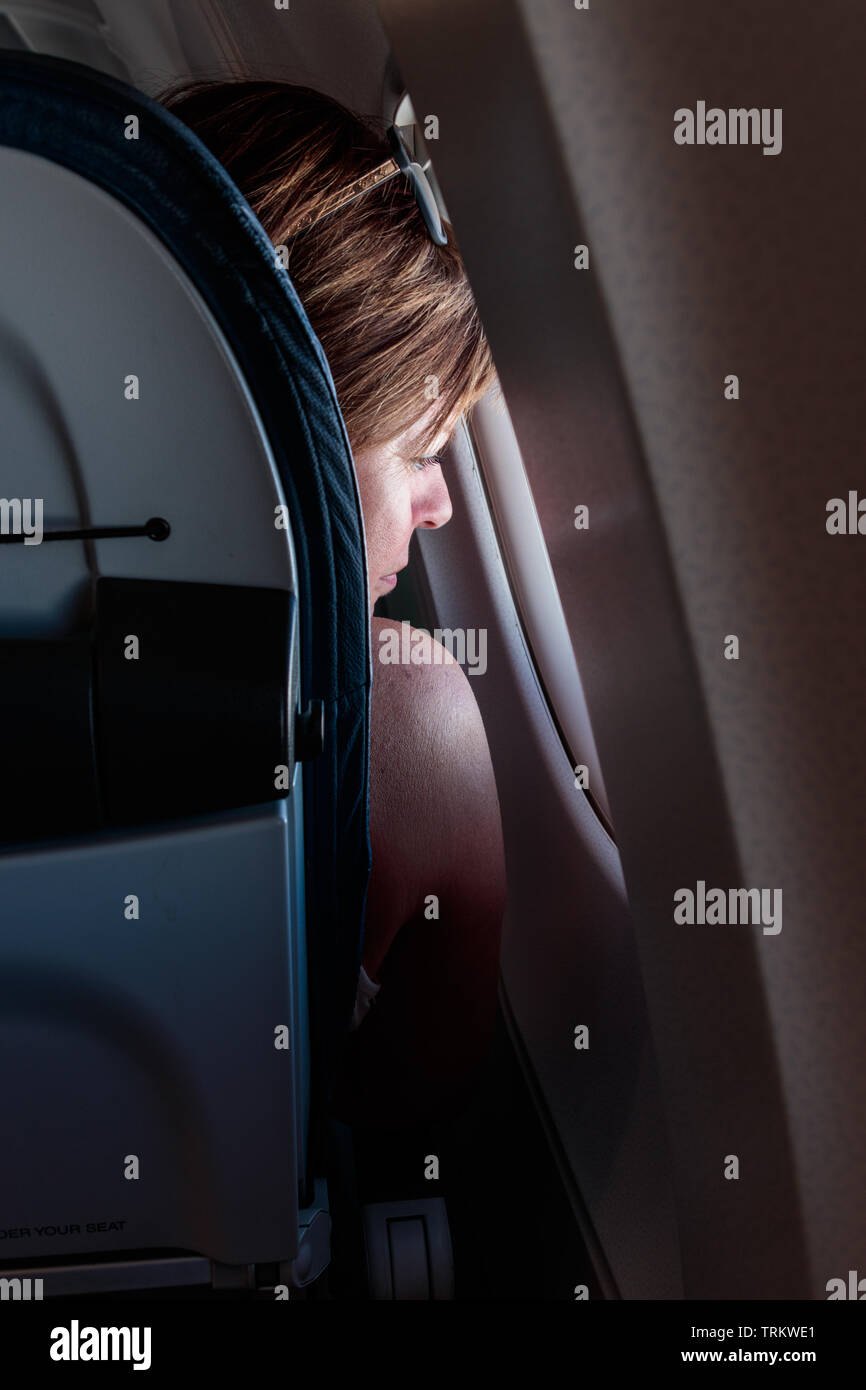 Woman looking through window of plane hi-res stock photography and ...