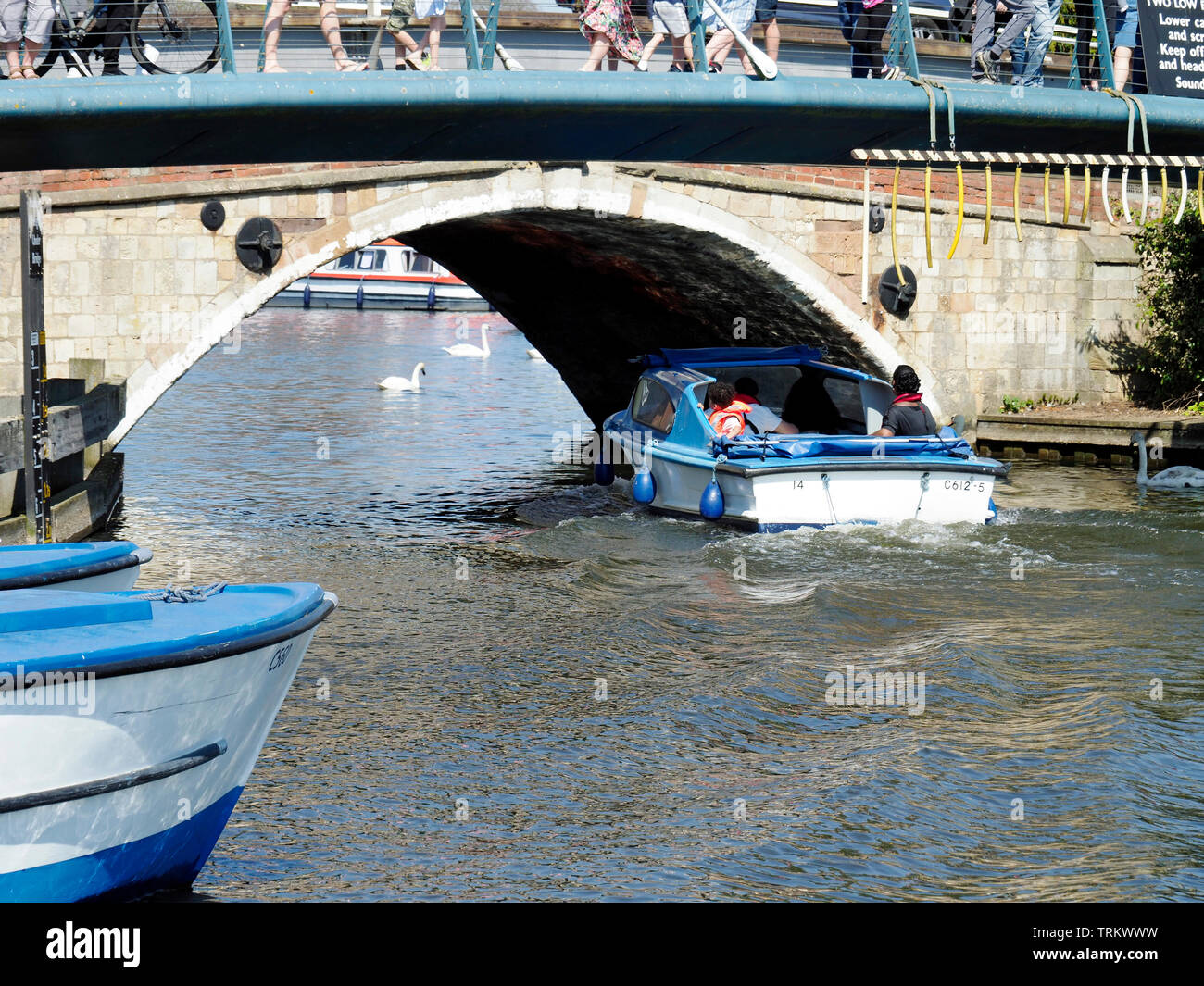 A small launch approaches the historic Wroxham Bridge. Day launches are ...