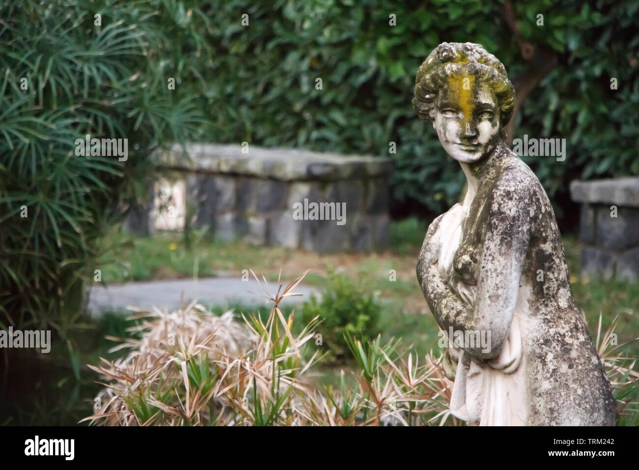 Marble statue of a bather in an abandoned park in Italy on the slope of ...