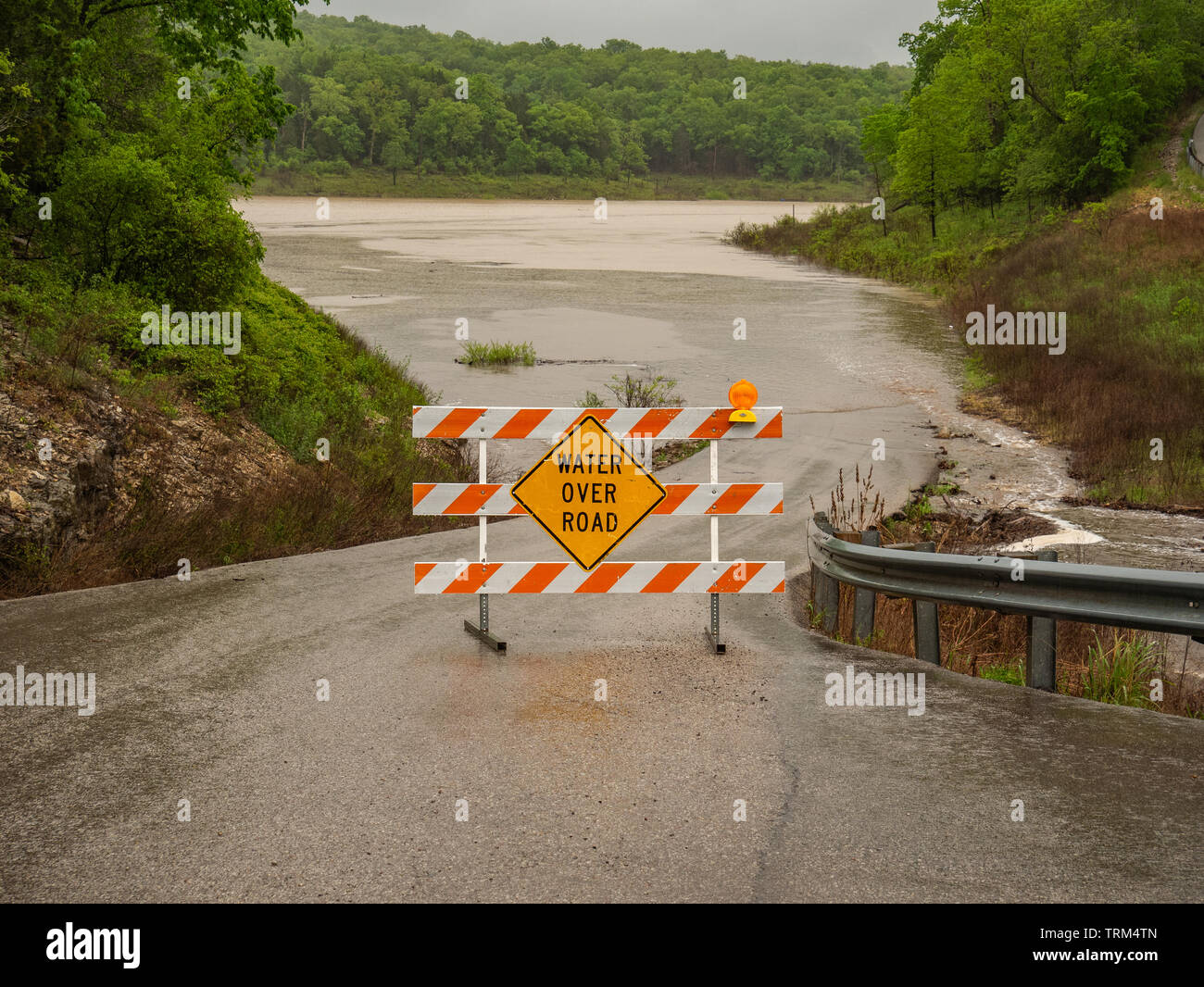 Water over road warning for flooding Stock Photo - Alamy