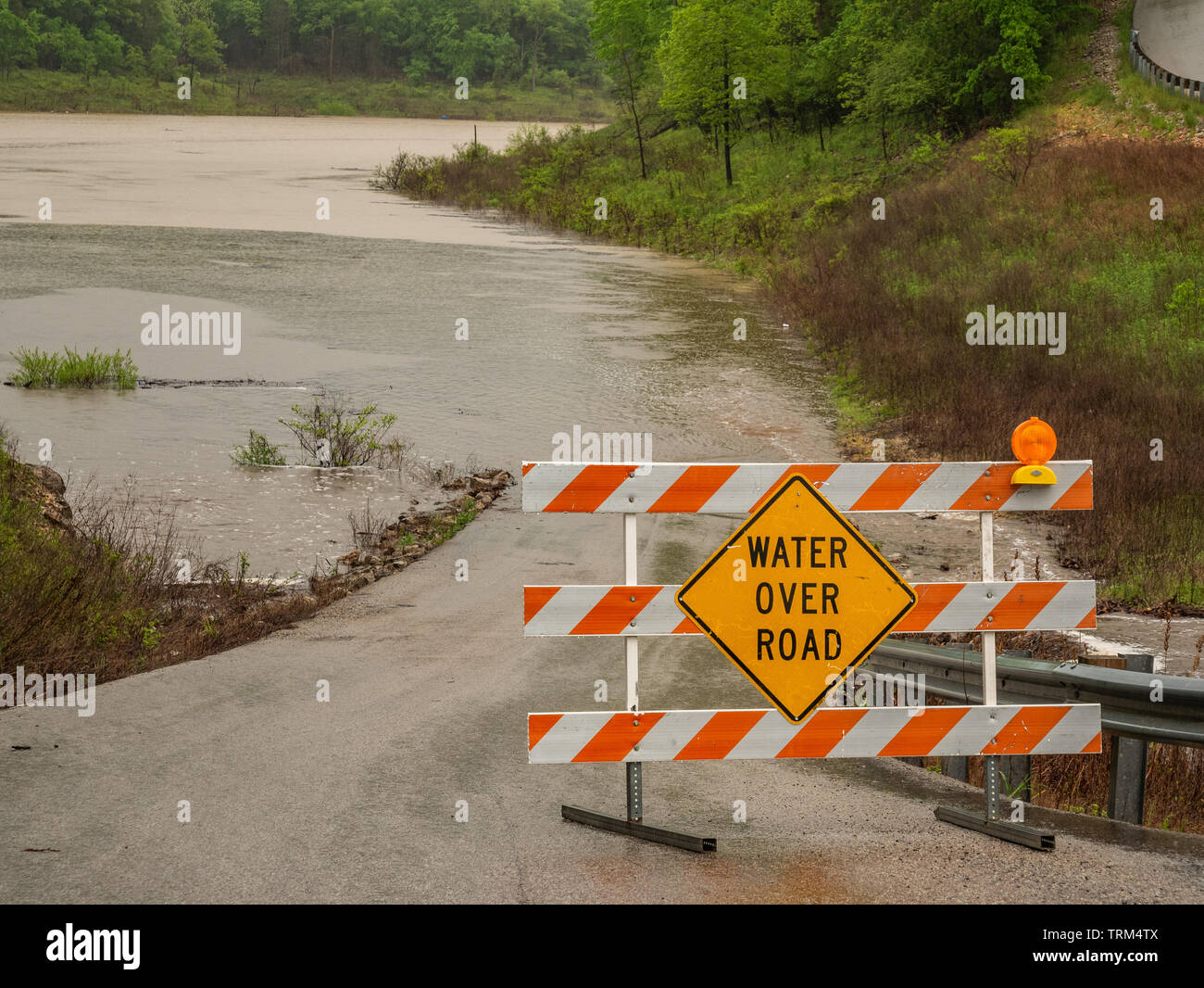 Water over road warning for flooding Stock Photo - Alamy