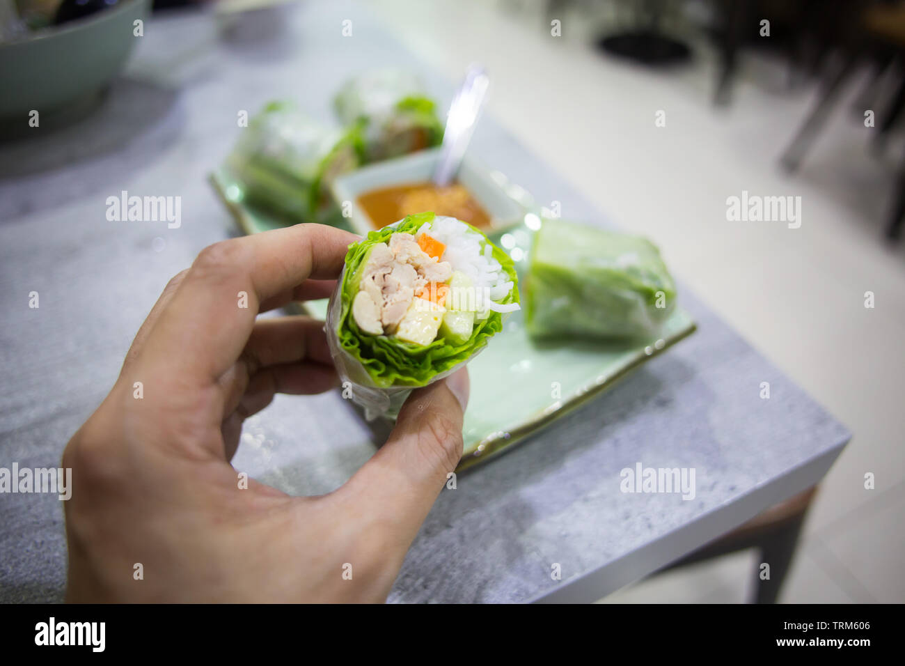Perspective of left hand holding a spring roll ready to eat it Stock ...